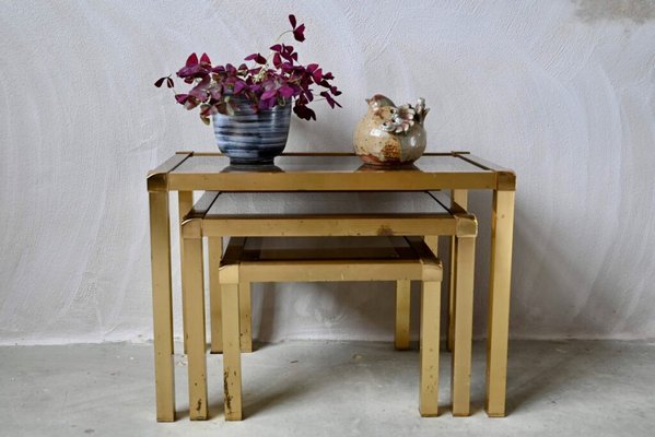 Hollywood Regency Style Nesting Tables or Flying Tables in Gold Metal and Smoked Glass 1970s Set of 3
